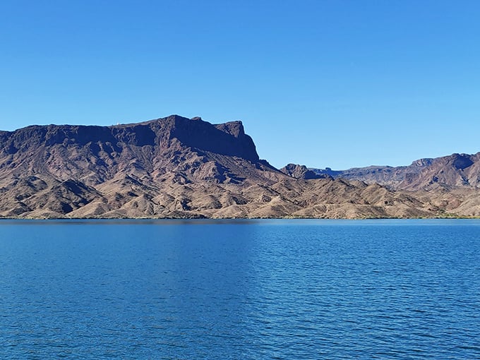 Mountains rising like ancient guardians from the Colorado River's edge. If these rocks could talk, they'd probably say, "Take more photos, but leave no trace." 