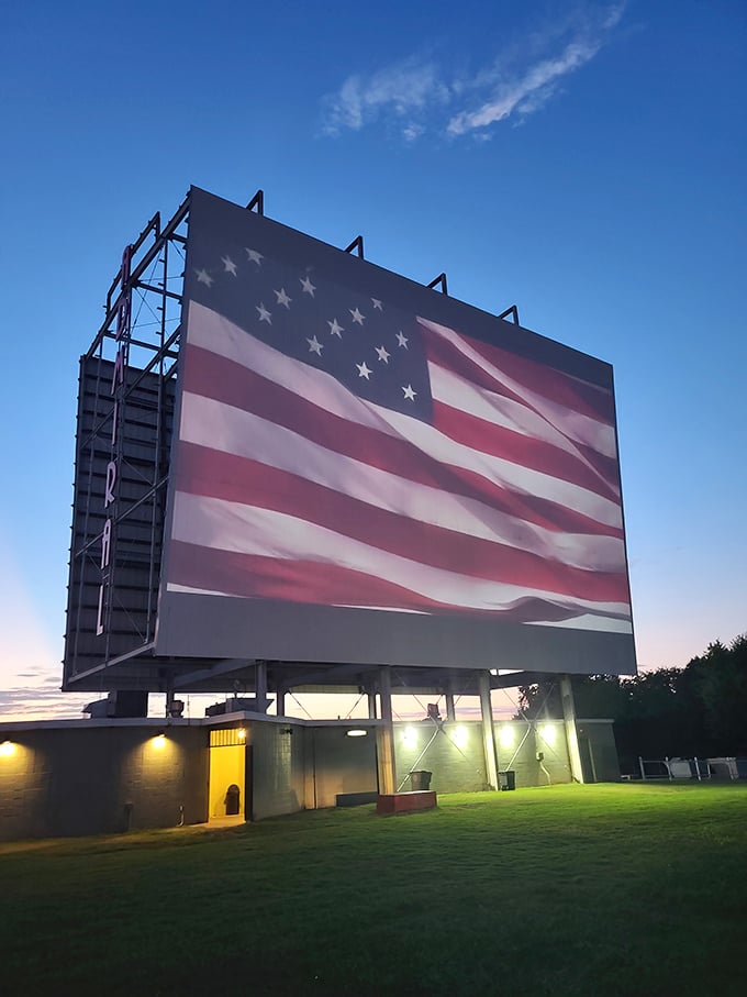 Old Glory waves proudly on the screen, reminding us that few experiences are as quintessentially American as the drive-in theater.