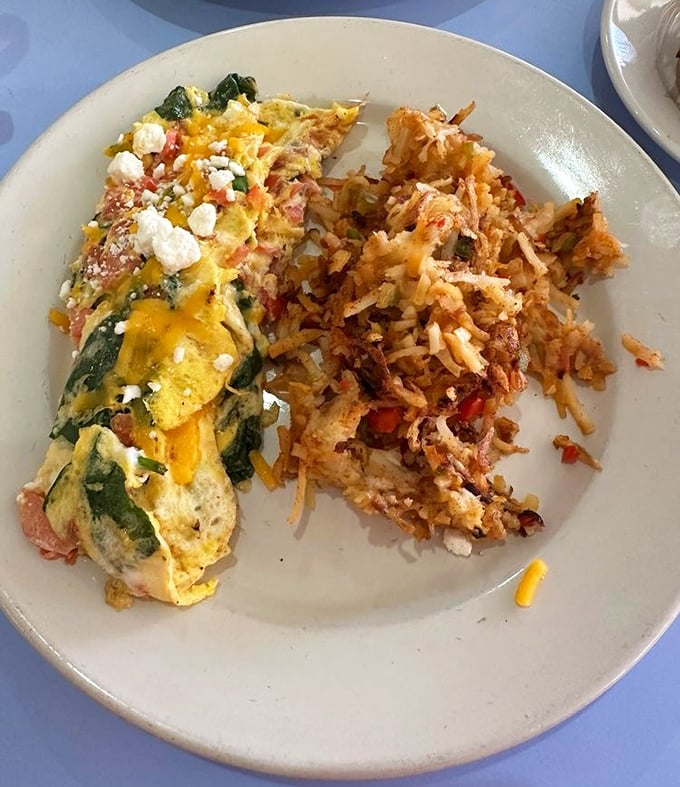 An omelet that doesn't just contain vegetables but celebrates them, paired with hash browns that achieve the golden-brown perfection we all attempt at home.
