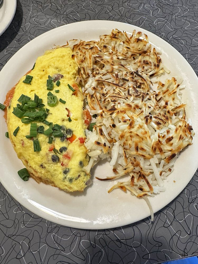 The perfect omelet relationship: fluffy eggs on one side, crispy hash browns on the other, neither trying to change the other.