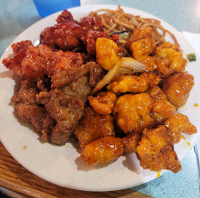 The holy trinity of Chinese-American comfort: orange chicken, sweet-and-sour pork, and chow mein that's worth every carb-laden twirl.