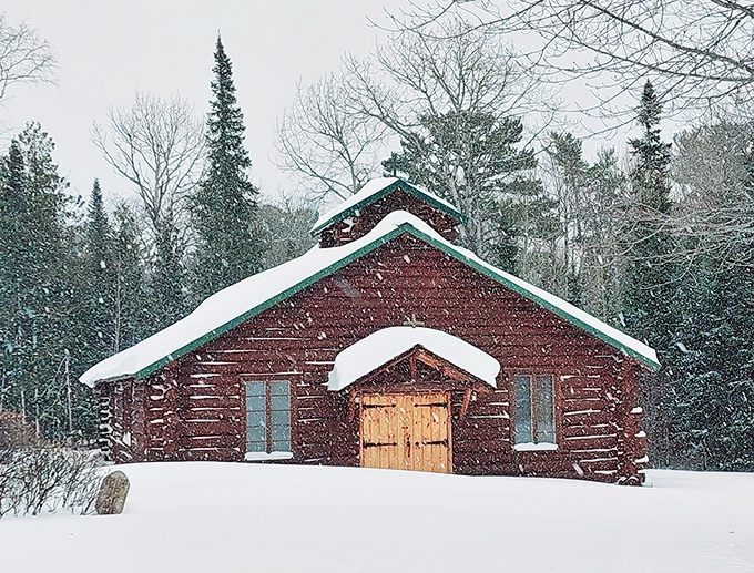 Winter transforms this rustic log chapel into a Christmas card come to life. Our Lady of the Pines stands serene under its snowy blanket, a spiritual anchor in wilderness.
