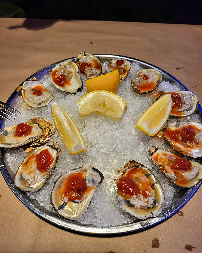 Fresh oysters on the half shell, arranged like a briny clock face with lemon wedges marking the hours. A splash of hot sauce adds just the right kick.