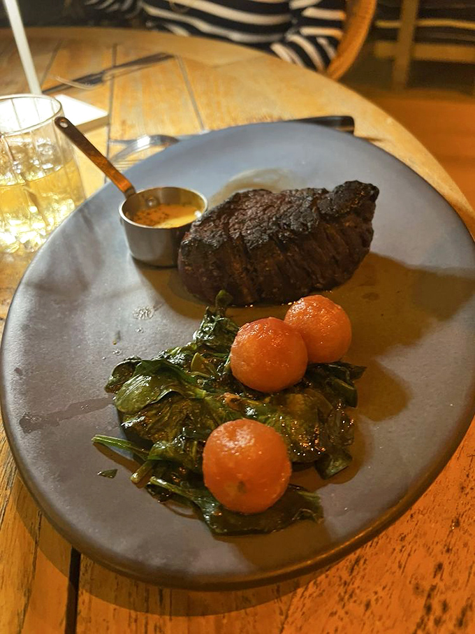 This steak doesn't just sit on the plate &ndash; it commands attention, while those bright tomatoes and greens provide perfect supporting roles.