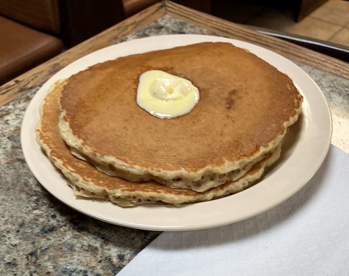 These pancakes aren't just big &ndash; they're Florida-sized. Golden, fluffy discs of joy with that perfect butter crown melting into breakfast nirvana.