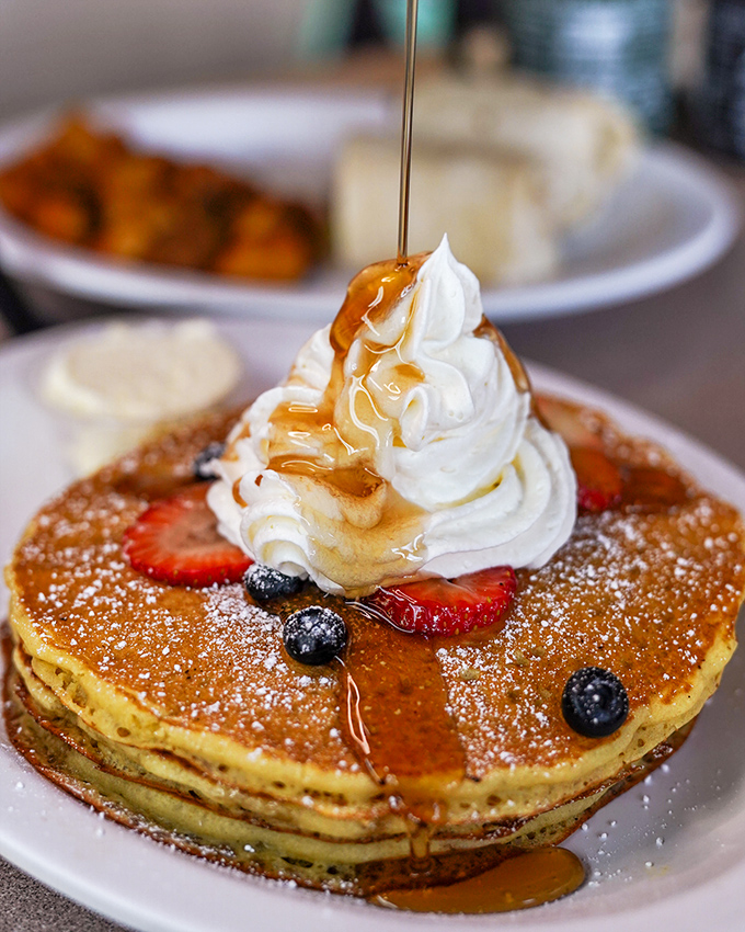 Those pancakes topped with berries, whipped cream, and syrup represent everything right with the world, stacked high and ready for glory.