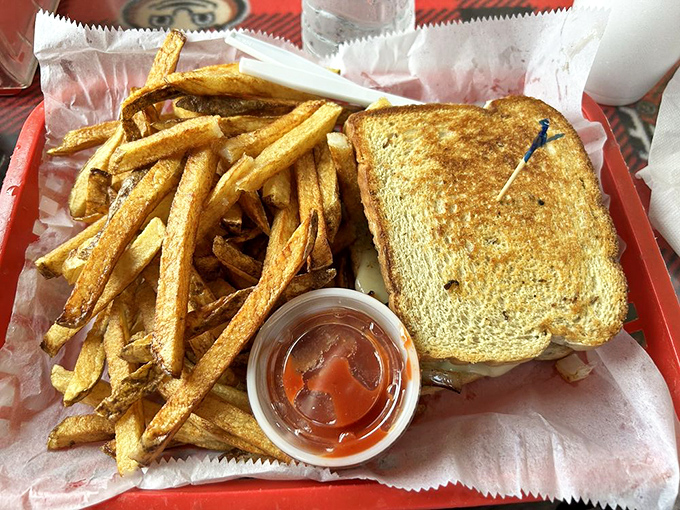 A perfectly grilled patty melt that would make your grandmother proud, nestled beside fries that clearly graduated from potato university with honors.