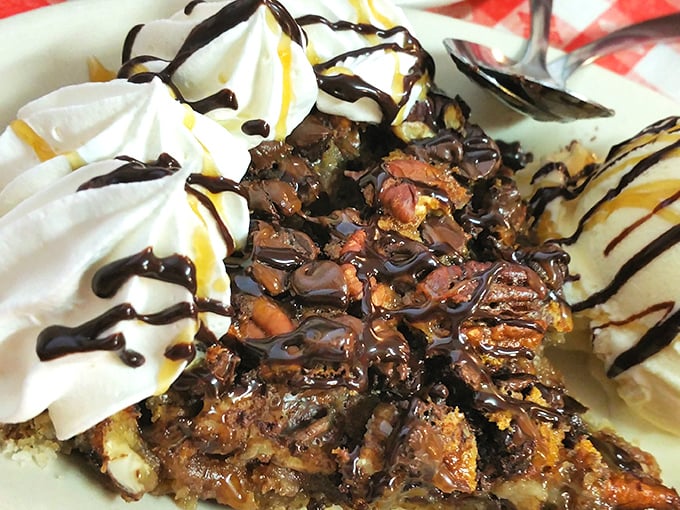 This pecan pie topped with whipped cream and chocolate drizzle is basically happiness served on a plate.