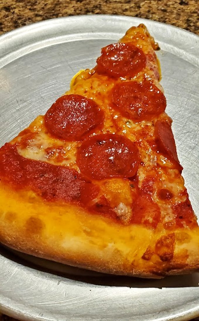 Each pepperoni curls into a perfect little cup, creating tiny pools of savory goodness that make this slice irresistible.