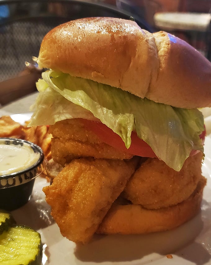 A perch sandwich so generously portioned it requires architectural planning to eat, served with tartar sauce and zero regrets about carbs.