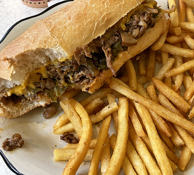 The star of the show: Village Diner's legendary Philly cheesesteak with tender ribeye, melted cheese, and saut&eacute;ed onions alongside crispy fries.