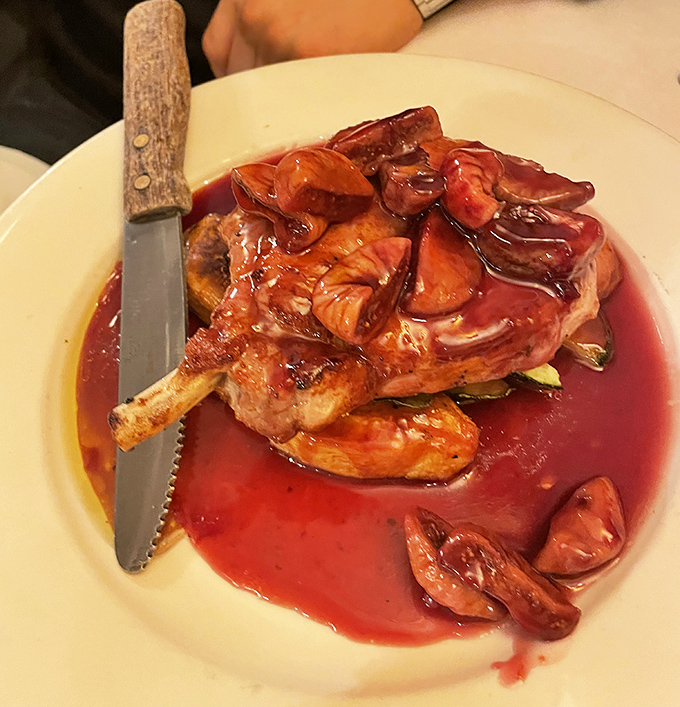 This pork chop isn't just dinner, it's a statement. Bathed in a ruby-red wine reduction with roasted tomatoes, it's the dish that launches a thousand food memories.