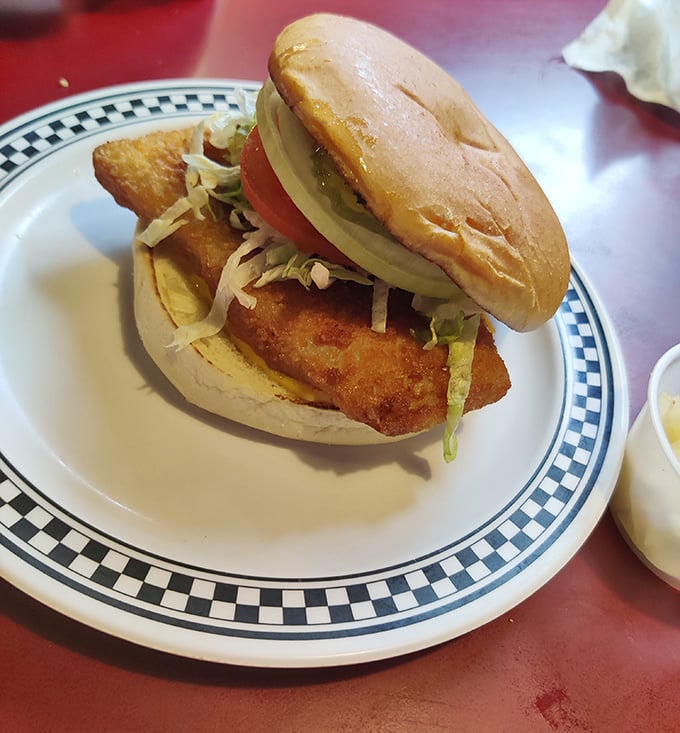 A proper pork tenderloin sandwich that refuses to acknowledge the boundaries of its bun – Midwest portion control at its finest.