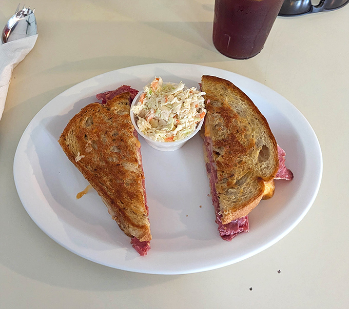 This Reuben isn't just a sandwich; it's architecture &ndash; perfectly balanced layers of corned beef, Swiss, and sauerkraut with coleslaw standing guard.