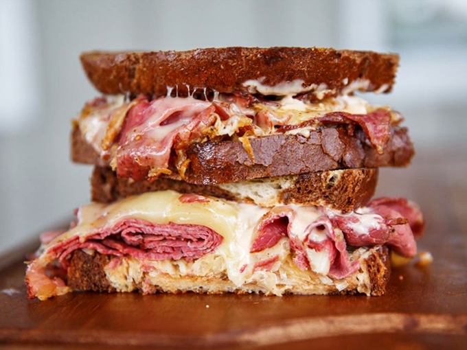 This isn't just a sandwich; it's architecture. Layers of meat and cheese stacked with the precision of a Jenga master who moonlights as a deli worker.