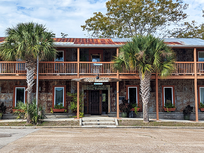 The Riverwood Suites embodies Old Florida charm with its weathered brick facade and palm-flanked porch – no high-rise required.