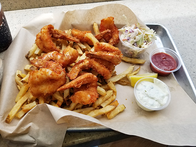 Golden-battered shrimp perched atop hand-cut fries—proof that sometimes the simplest pleasures are the most profound.