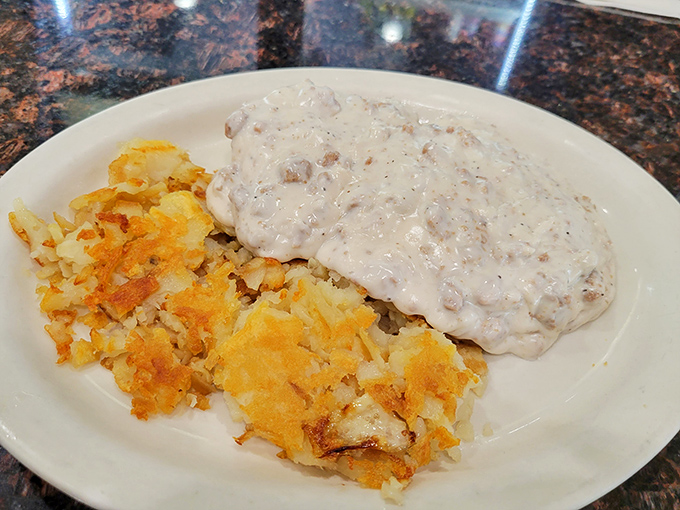 Biscuits and gravy alongside golden hash browns &ndash; the kind of plate that makes you want to cancel your plans and settle in for the day.