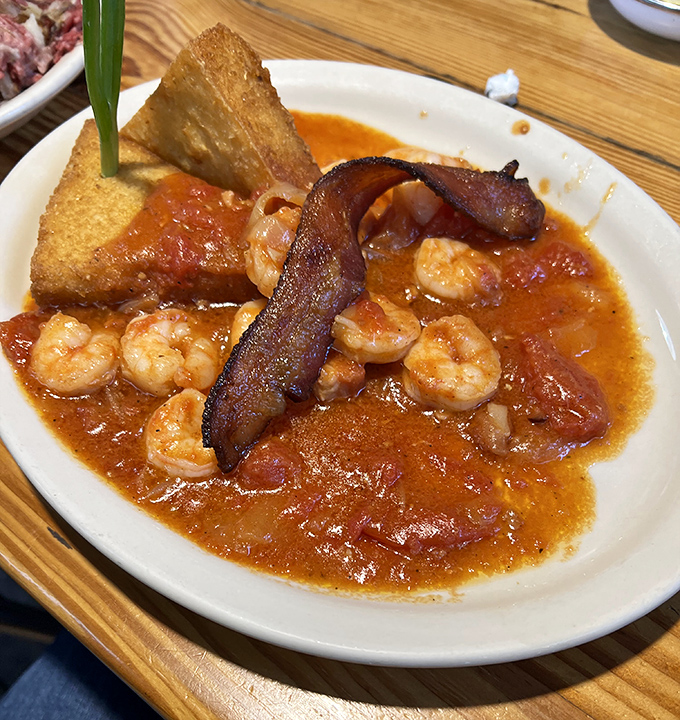 The Shrimp and Grits arrive like a savory love letter from the Gulf &ndash; plump shrimp swimming in rich gravy alongside cornbread that's worth the drive alone.