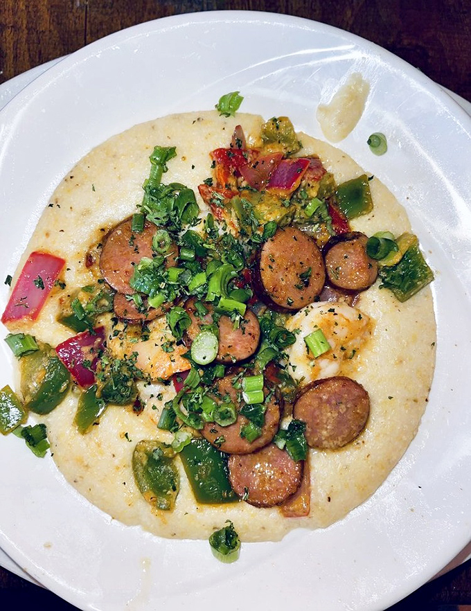 This isn't just grits—it's a Southern symphony. Creamy stone-ground goodness topped with andouille sausage, peppers, and green onions that would make any grandma proud.