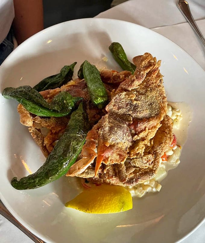 Soft shell crab perched atop creamy corn like Neptune rising from the sea, with shishito peppers standing guard over this crispy treasure.