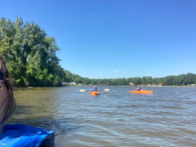 Kayakers paddle across Spring Lake's tranquil waters, proving that inland Iowa offers waterfront recreation that rivals coastal communities&mdash;minus the sharks and attitude.