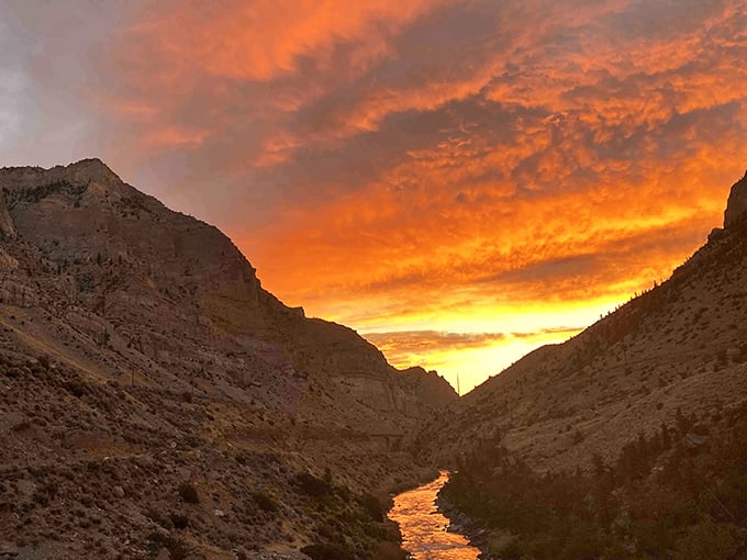 Wind River Canyon at sunset transforms into nature's light show, where fiery skies illuminate ancient rock walls that whisper geological secrets.
