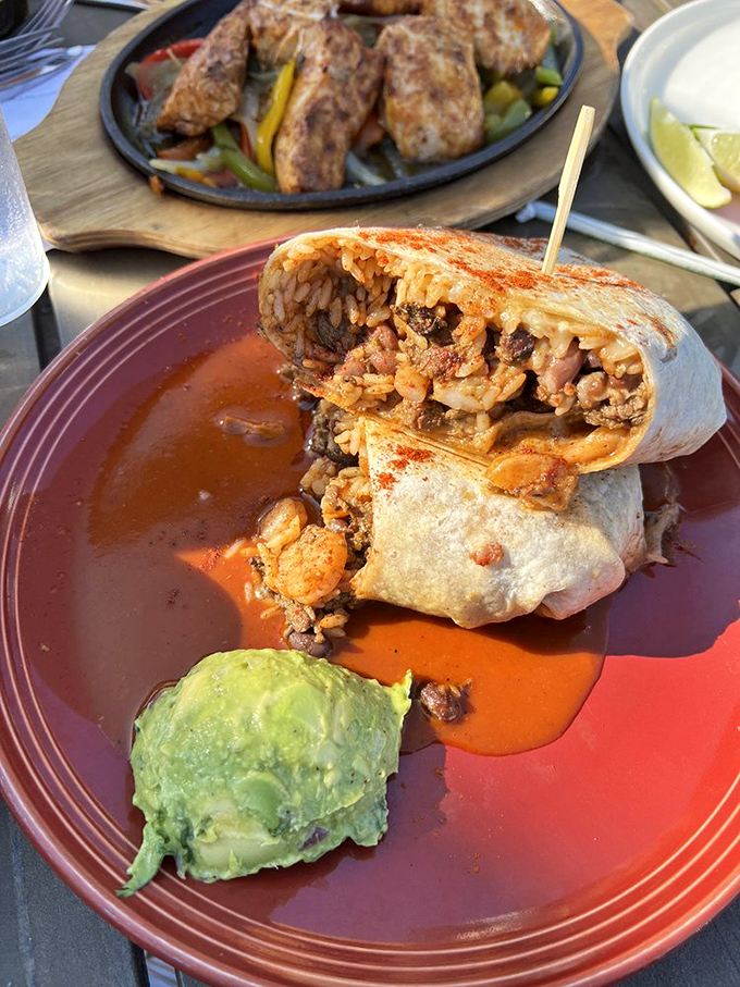 The surf and turf burrito: where land meets sea in a tortilla embrace. That scoop of guacamole is the emerald crown jewel of this plate.