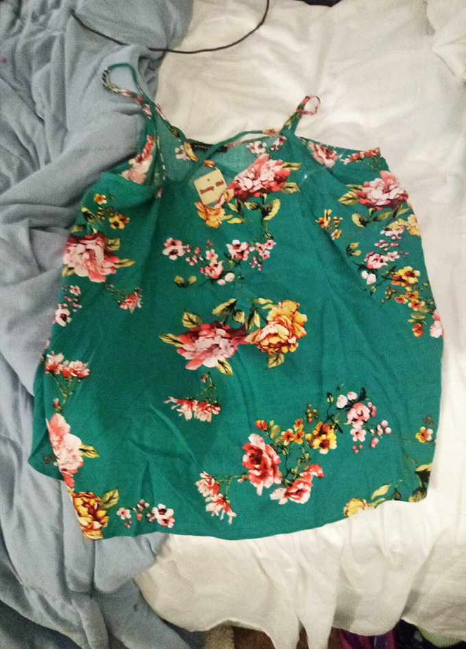 This floral tank top still has its tags &ndash; proof that someone else's shopping regret becomes your fashion statement.