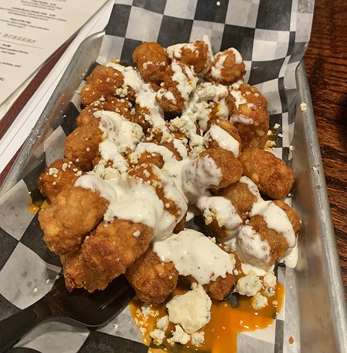 These golden tater tots arrive drizzled and dressed like they're heading to prom, crispy and ready to steal the show.
