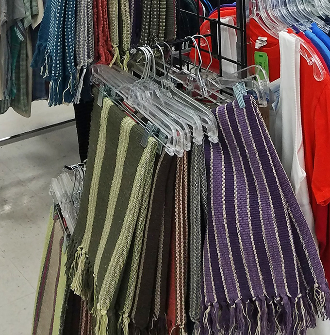 Vintage throw rugs hang like textile tapestries, each pattern telling stories of living rooms past.