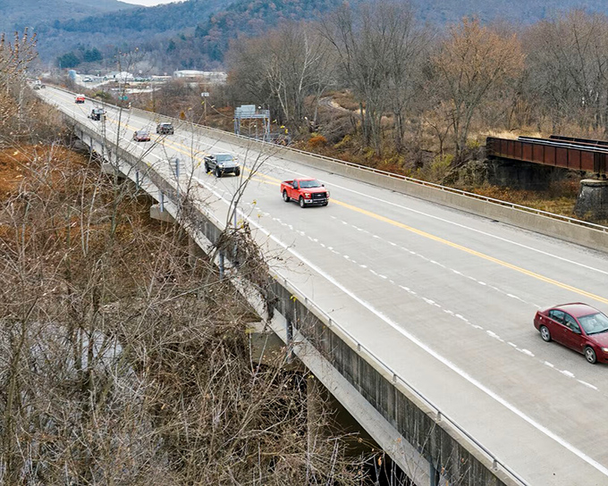 The bridge stretches across the valley like a concrete ribbon, connecting communities while offering drivers a moment of suspended panoramic bliss.