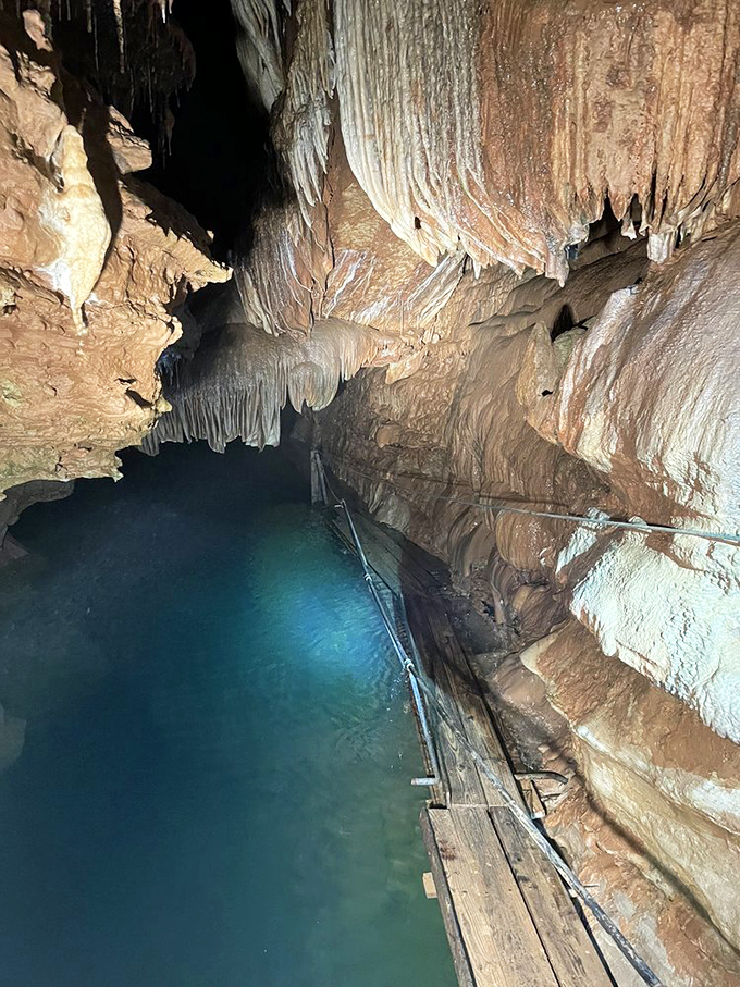 The underground river glows with an otherworldly radiance, reflecting millions of years of geological artistry in its pristine surface.