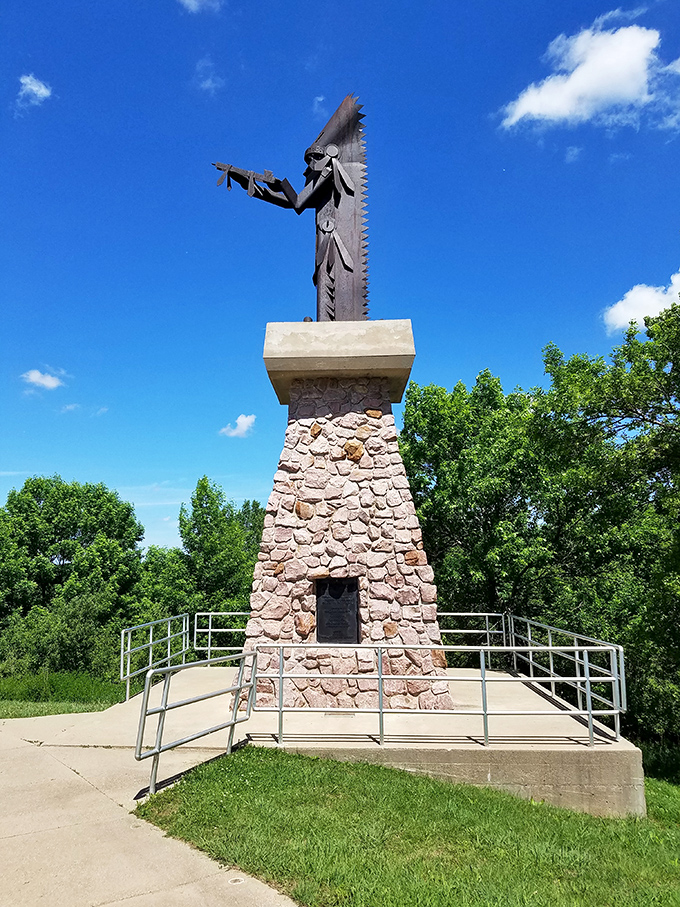 This striking Native American monument reaches skyward against an impossibly blue Iowa sky, honoring the indigenous heritage that shaped the region.