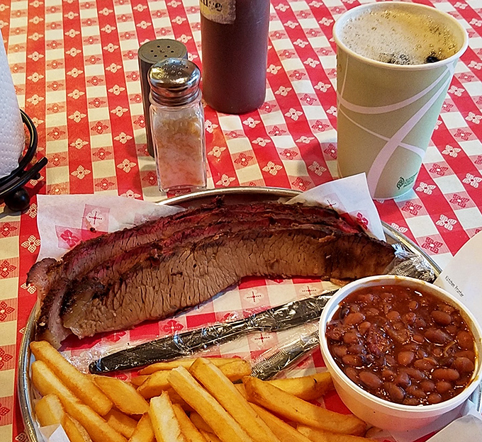Behold the brisket! That smoke ring is the mark of true barbecue artistry. Served with beans and fries, this platter is pure, savory heaven. Dig in!