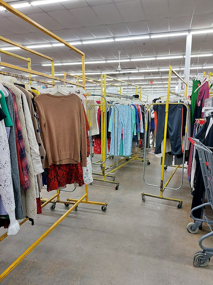 The clothing racks stretch toward retail infinity, each yellow frame supporting dozens of potential wardrobe transformations at prices that feel like typing errors.