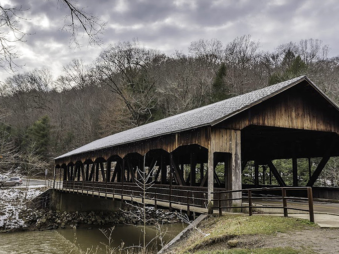 The covered bridge in winter wears a light dusting of snow like powdered sugar on the world's most rustic donut.