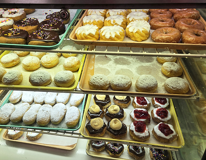 Pastry paradise in full display. From powdered donuts to cream-filled delights, this case is where willpower comes to surrender gracefully.