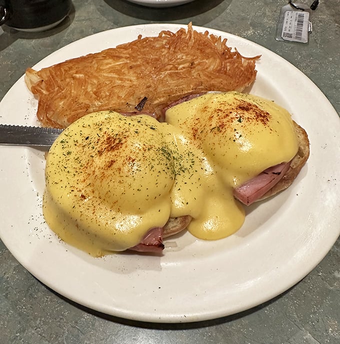 Eggs Benedict done right &ndash; perfectly poached eggs perched atop ham and English muffin, draped in sunshine-yellow Hollandaise with hash browns crispy enough to make you weep.