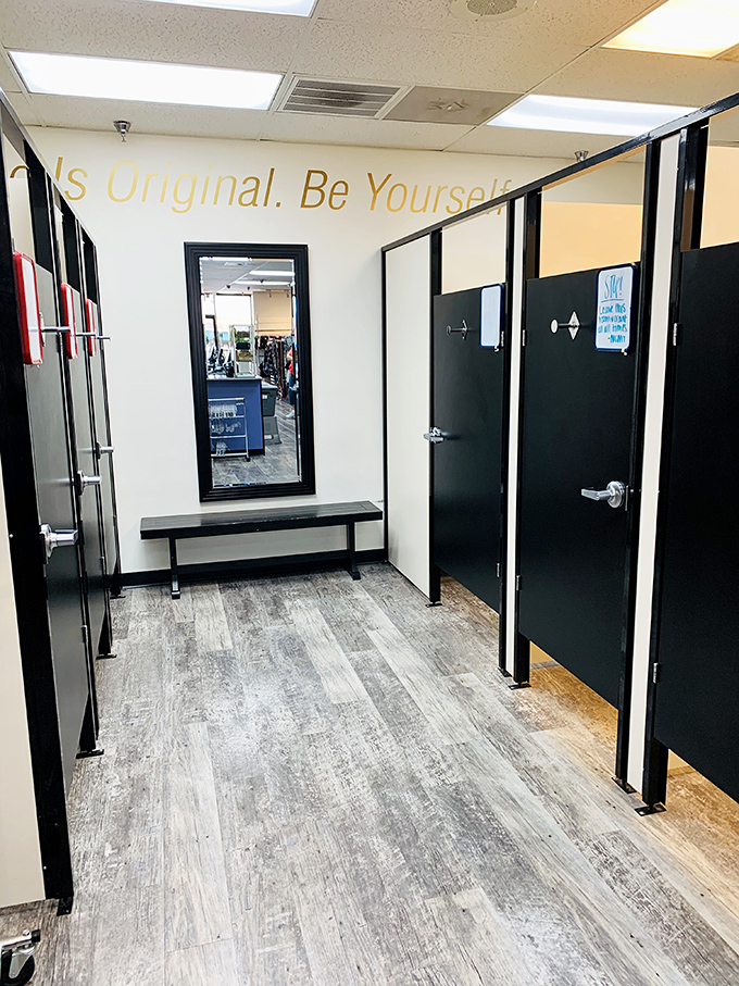 The fitting room area&mdash;where "Be Yourself" isn't just wall art but practical advice when trying on someone else's former fashion choices.