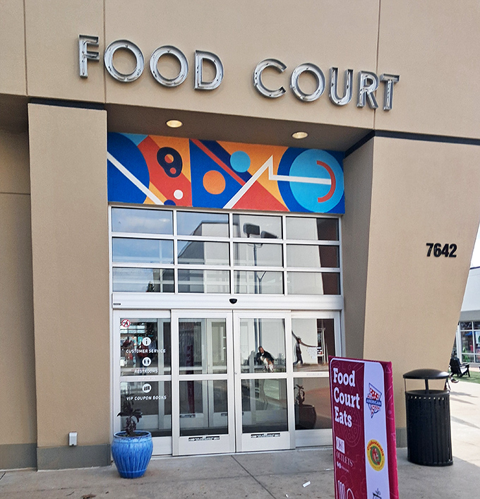 The food court entrance promises a culinary intermission between shopping marathons, with its colorful geometric design setting the mood.