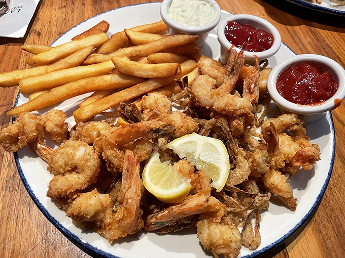 A mountain of perfectly fried shrimp that would make Forrest Gump weep with joy, accompanied by fries and the essential lemon wedge.