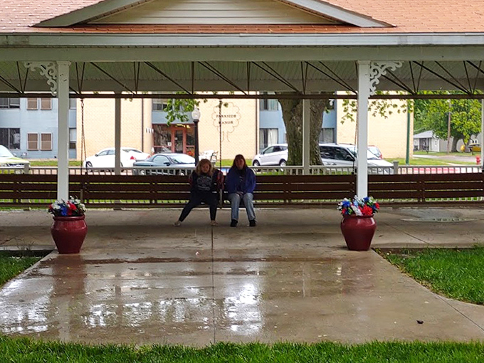 Rain or shine, the swing awaits. These visitors prove that even a drizzly day can't dampen the charm of this oversized slice of Americana.