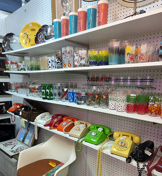 Colorful vintage glassware shares shelf space with rotary phones that once connected families before the era of smartphones and social media.