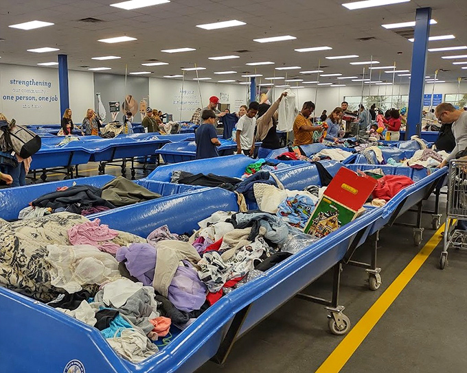 The synchronized swimming of secondhand shopping. Customers navigate the colorful currents of clothing with practiced precision and hopeful eyes.