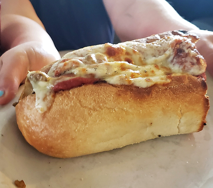 This isn't just melted cheese&mdash;it's a blanket of comfort tucked around a perfectly toasted garlic bread boat. The kind of sandwich that demands a nap afterward. 