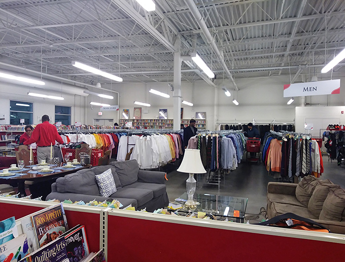 Men's apparel stretches into the distance while a gray sofa offers a perfect perch for the shopping-weary partner who's "just along for the ride."