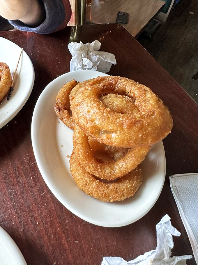Forget the chips, these onion rings are the unsung heroes! Perfectly crisp, lightly dusted—each one is a golden halo of pure, satisfying crunch.