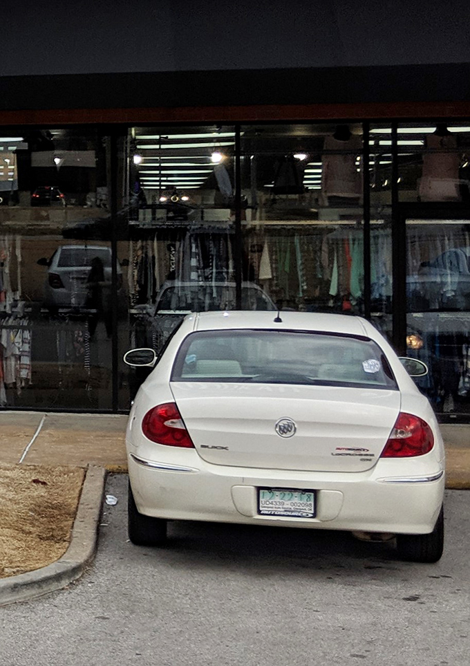 The storefront beckons after dark, clothing racks visible through large windows like a fashion oasis waiting to be discovered.