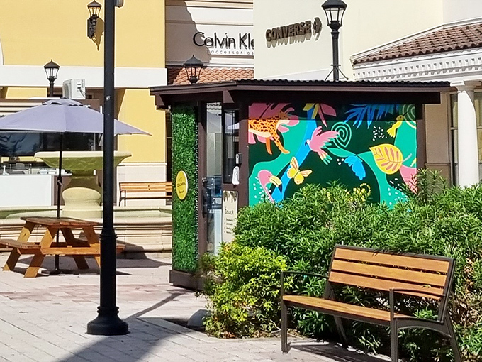 This vibrant mural rest area proves even outlet malls understand shopping is a marathon, not a sprint&mdash;bench breaks required.